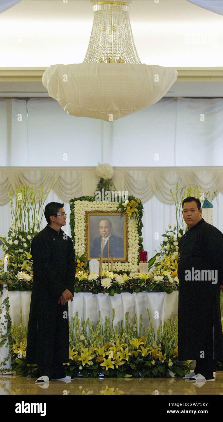 Workers stand in front of the portrait of Genting Group founder, Lim ...