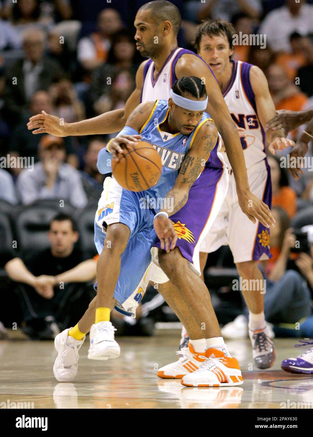 Denver Nuggets guard Allen Iverson, front, drives past Phoenix Suns forward Grant Hill during ...