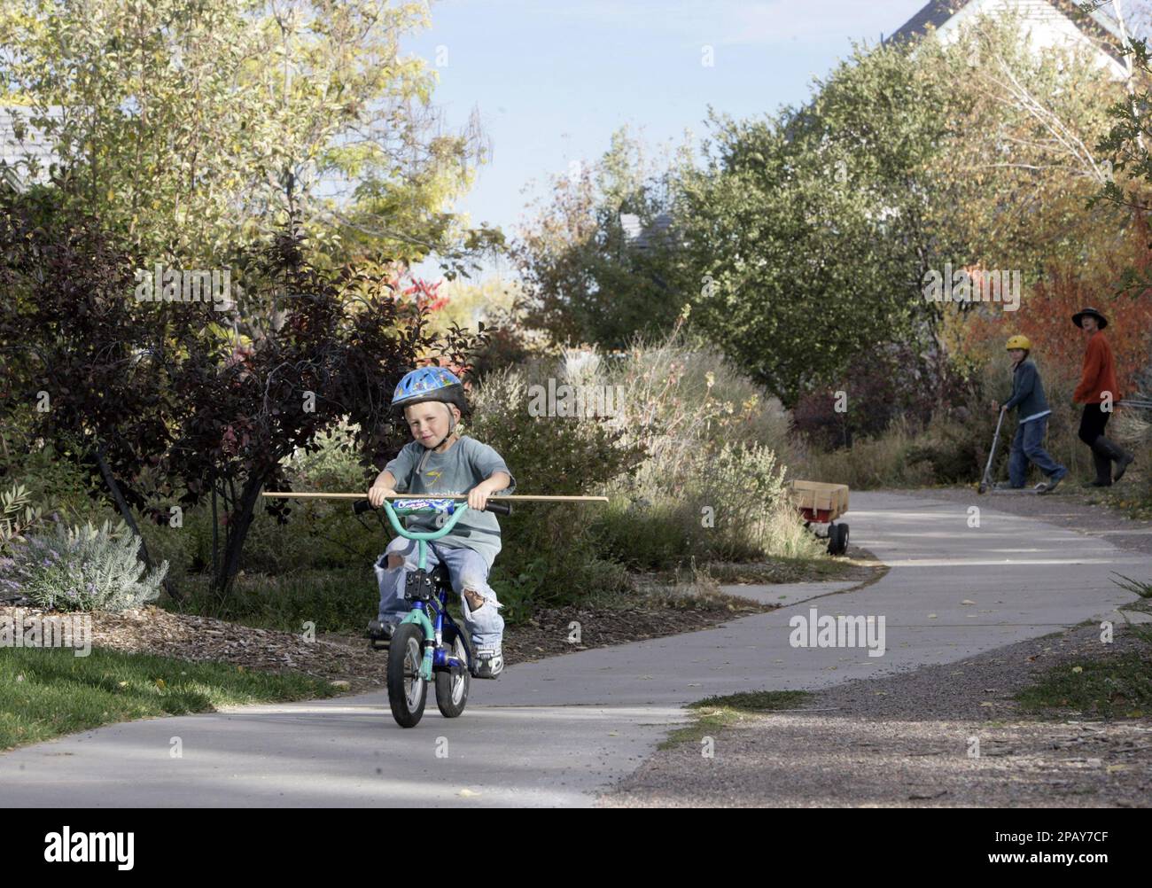 Four-year-old Conrad Cvar rides his bicycle on the path near his family ...