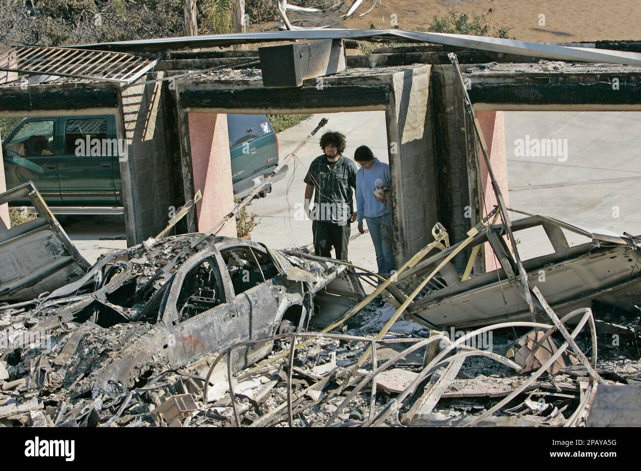Robert Zarrella and his sister, Kate, look over the burnt ruins of ...