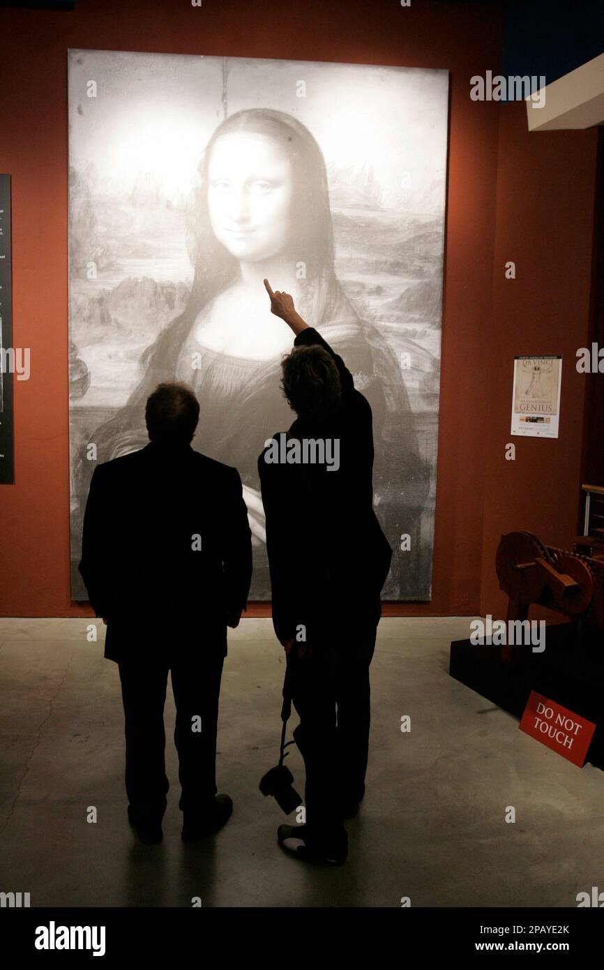 Engineer and inventor Pascal Cotte, left, examines a mural of an ...