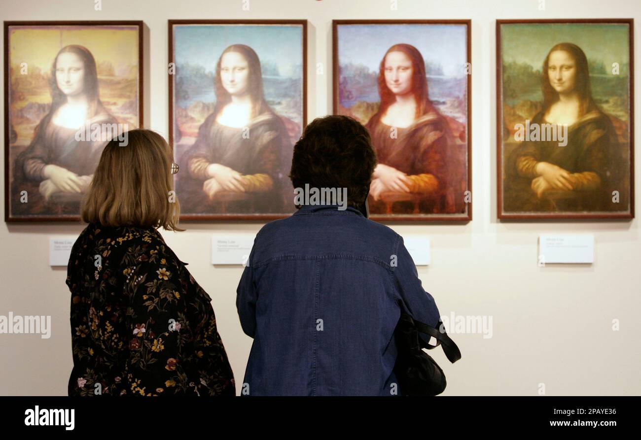 Visitors examine various versions of Leonardo da Vinci's "Mona Lisa" in ...
