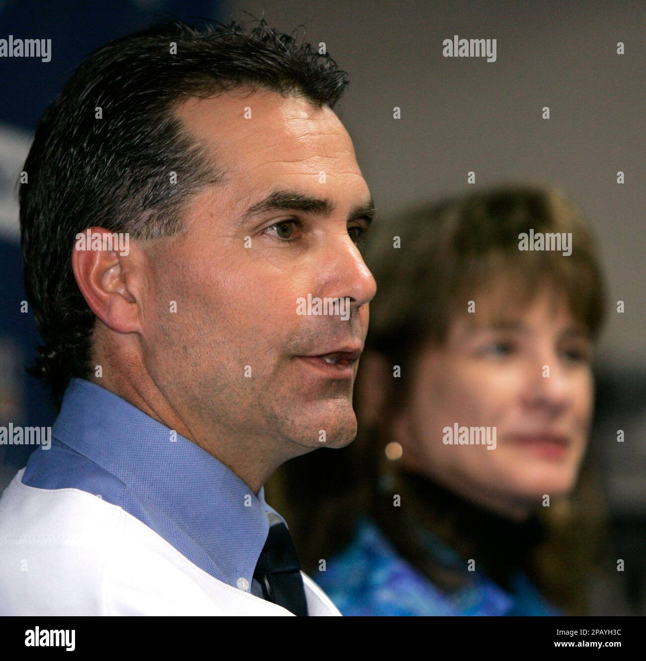 Trey Hillman, left, talks to the media while his wife Marie looks on ...