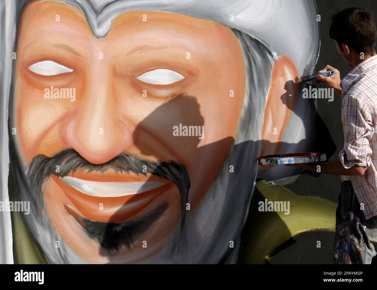 Disabled Palestinian artist Mohammed Shaban casts his shadow as he ...