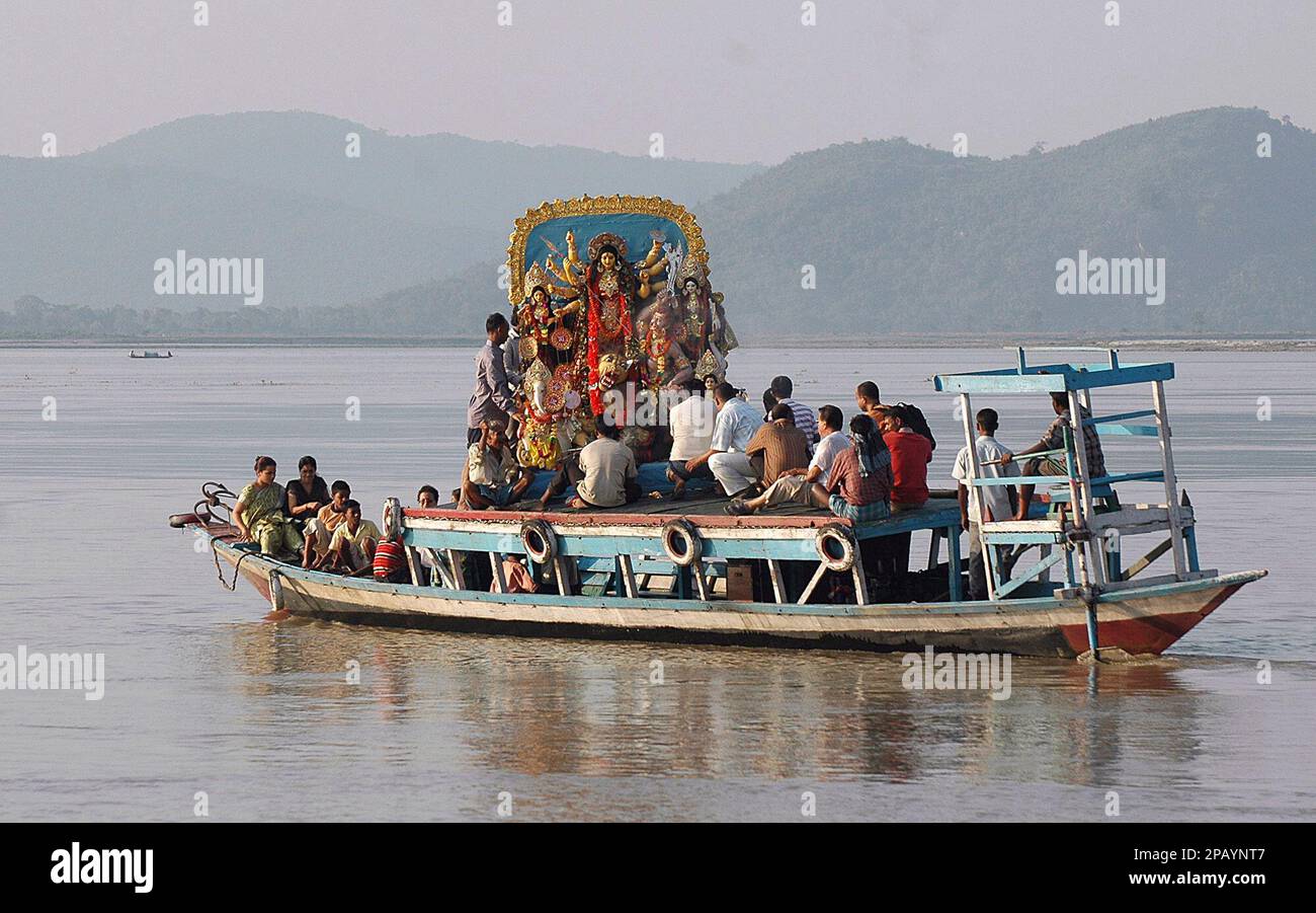 Devotees carry Goddess Durga idol on a boat for immersion in River ...