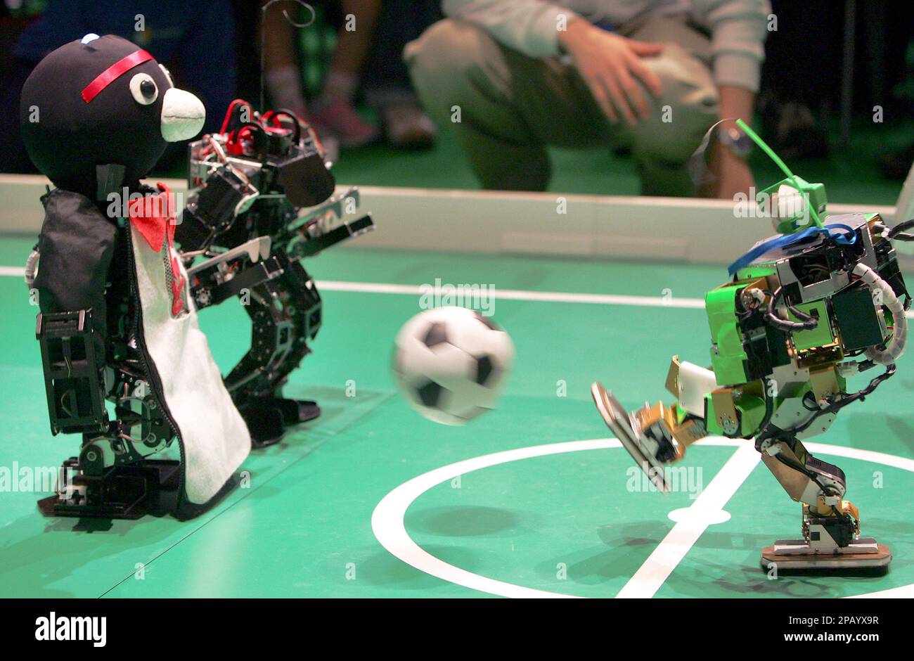 A robot, right, kicks a ball against opponent during a soccer match by ...
