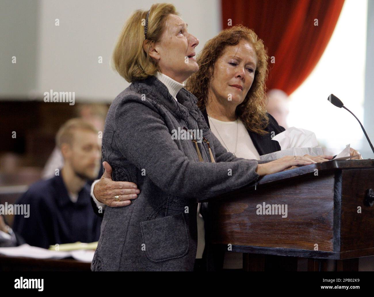 Laura Siklossy, left, is comforted by her sister, Sol Rainbow, as she ...