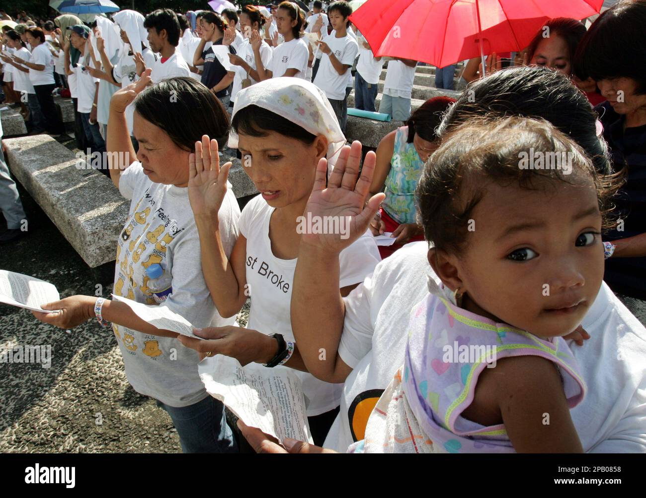 Filipino mothers recite a pledge to "Stand Up Against Poverty" during a ...
