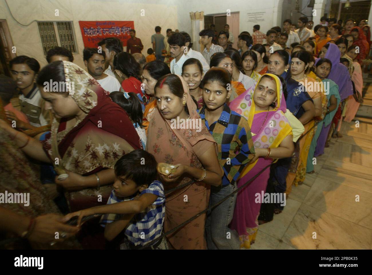 Hindu devotees stand in queue to pray at the Kalyani temple during ...