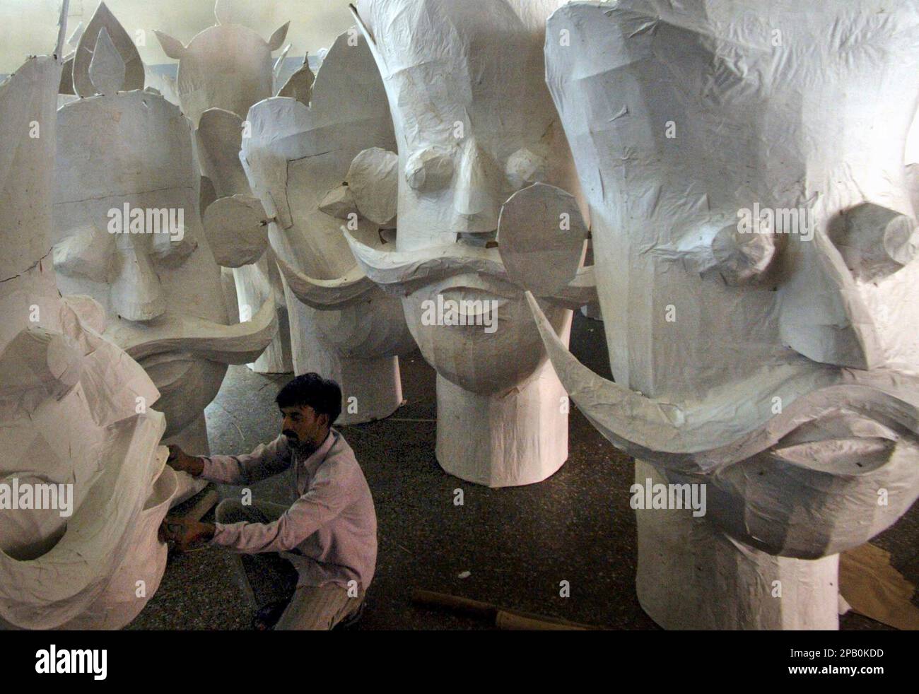 An artist works on the effigies of mythical demon king Ravana in Jammu ...