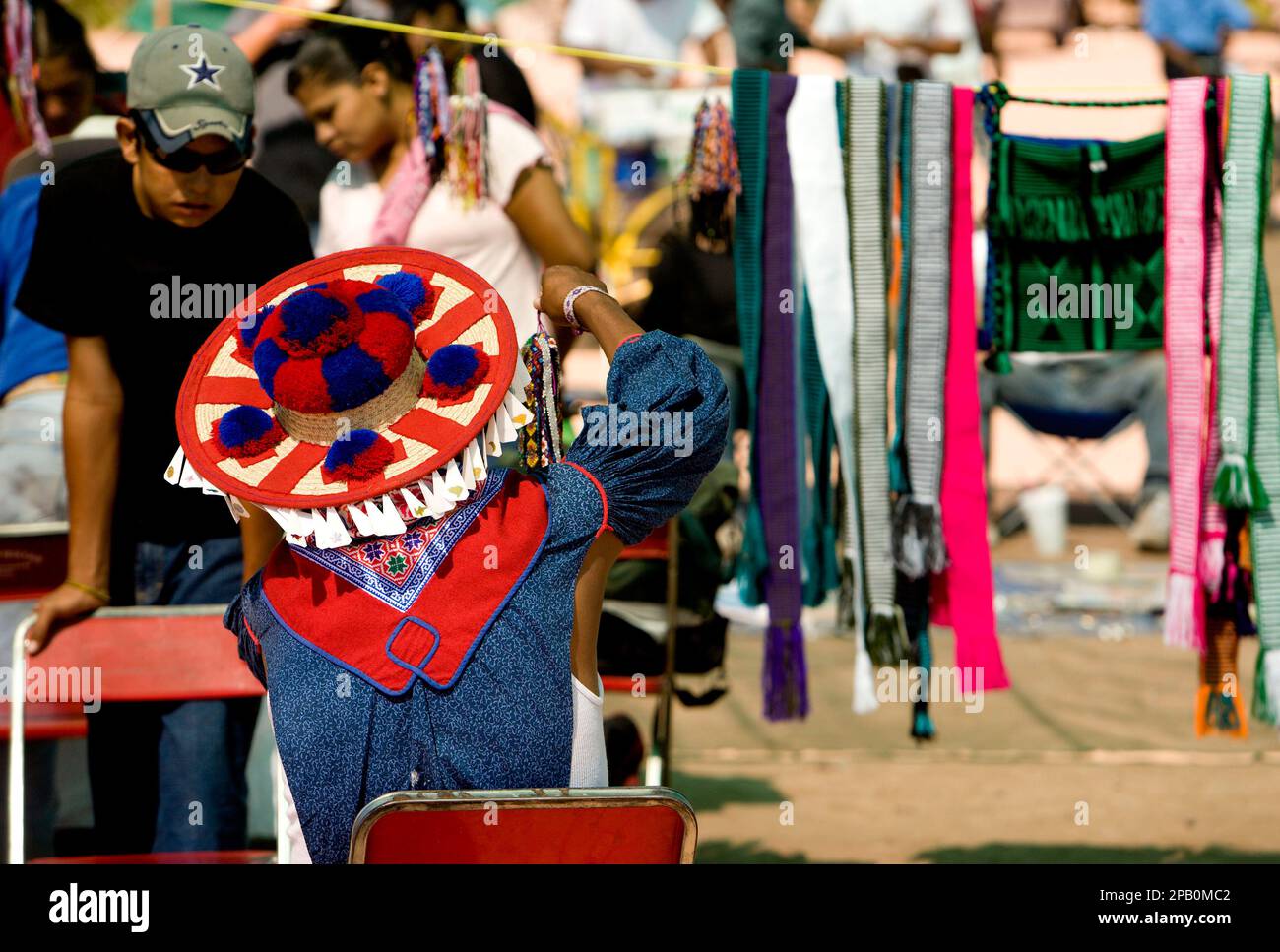 An indigenous man, front, offers his handcraft to costumers during the ...