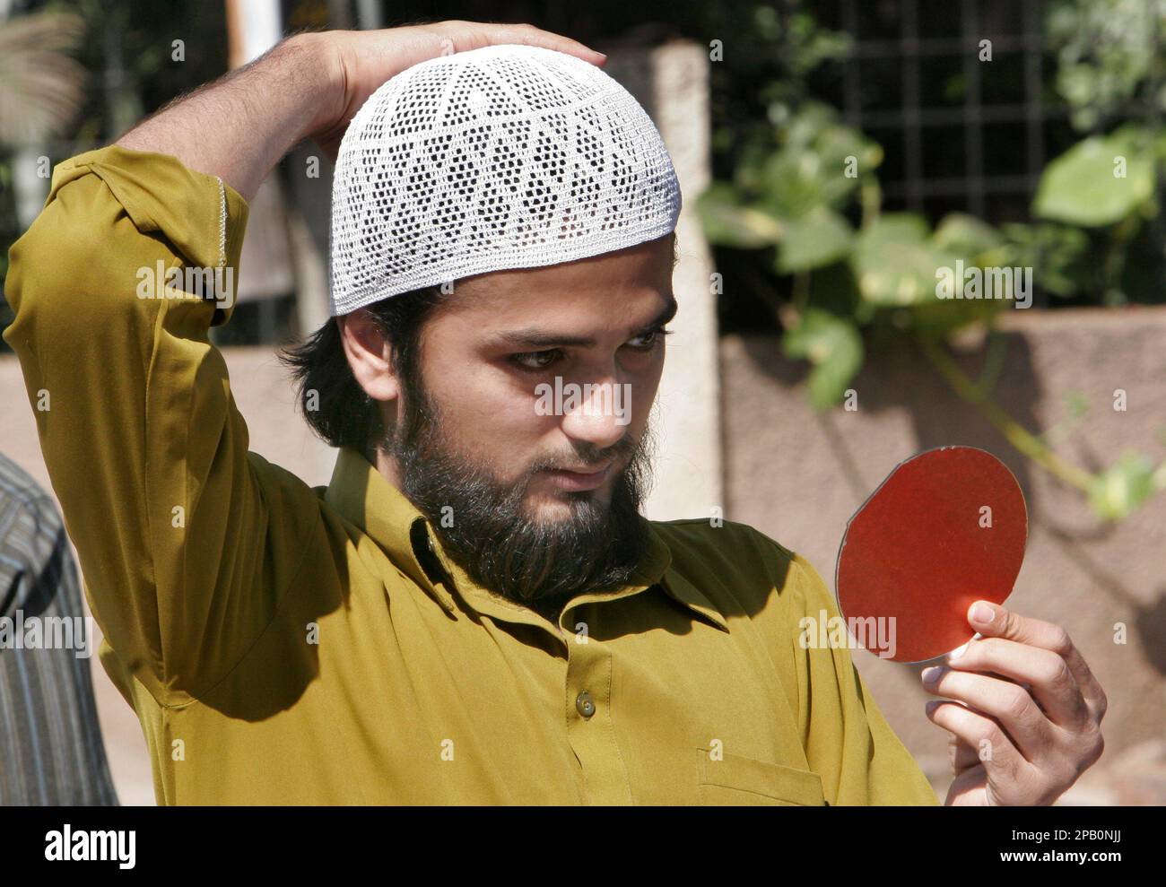 An India Muslim tries out a cap while shopping on the last Friday of ...