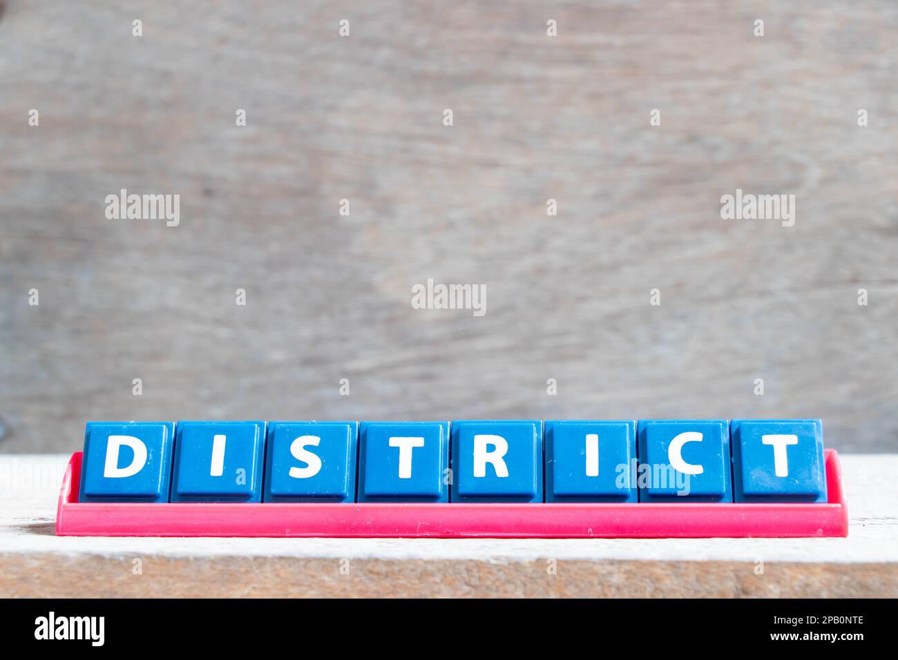 Tile alphabet letter with word district in red color rack on wood ...