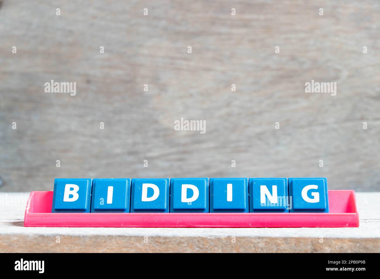 Tile alphabet letter with word bidding in red color rack on wood ...