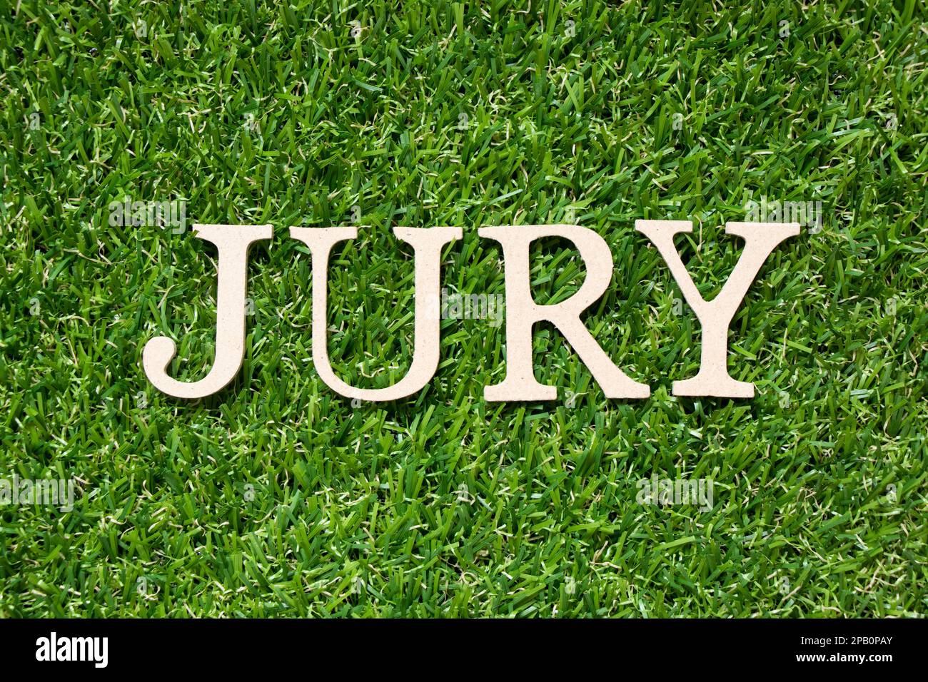 Wood alphabet letter in word jury on artificial green grass background ...