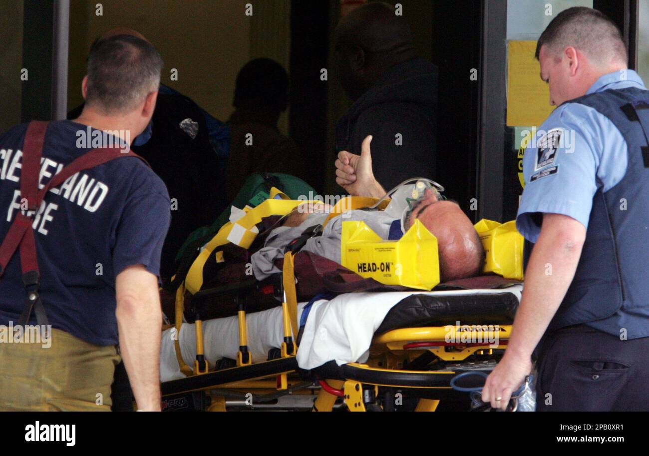 A male shooting victim gives the thumbs up as he is carried out on a ...