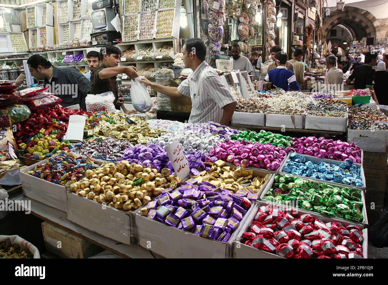 Syrians buy sweets from a shop just two days ahead of the Eid el-Fitr ...
