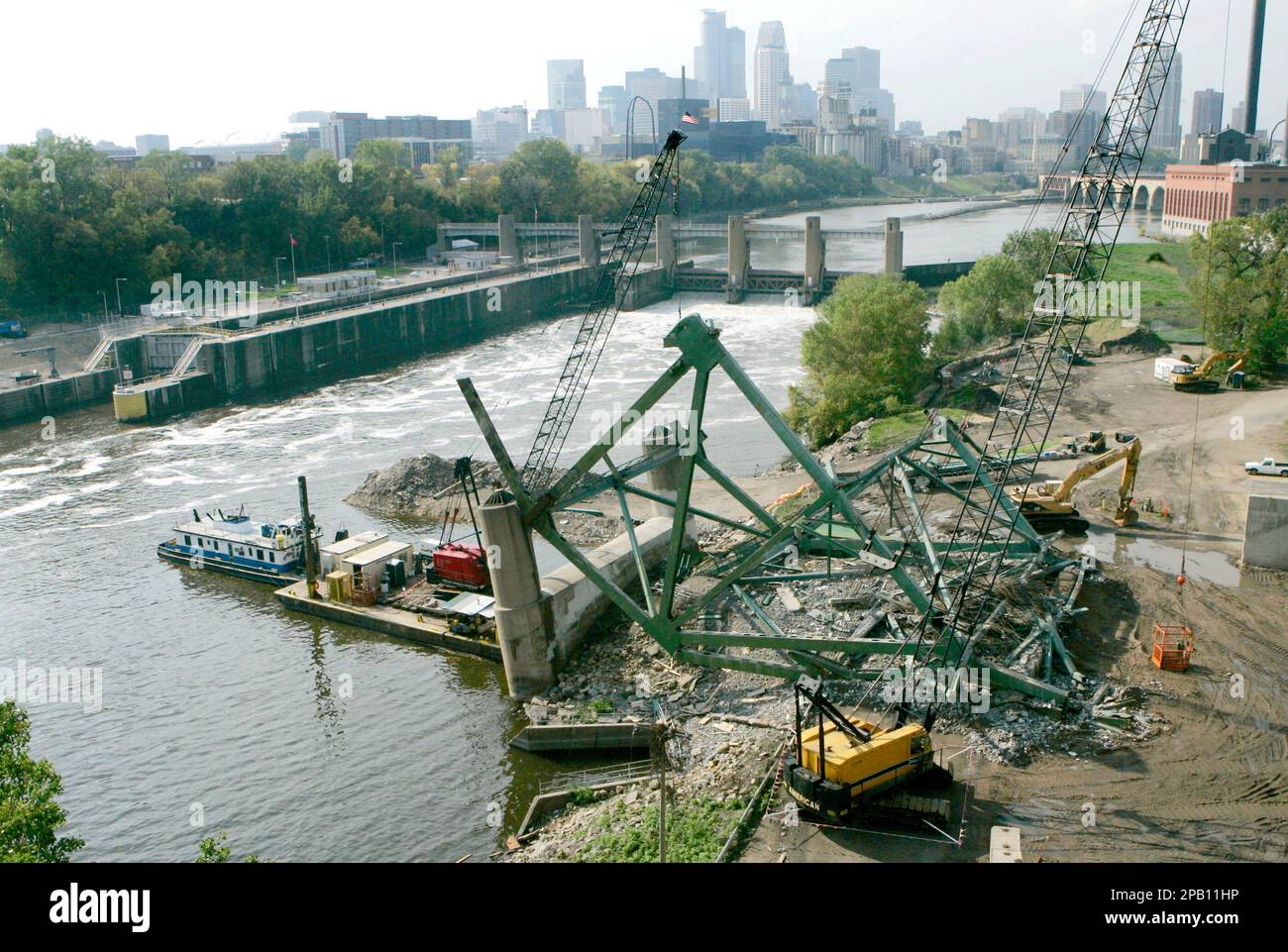The last of collapsed steel beams stand on land next to the Mississippi ...