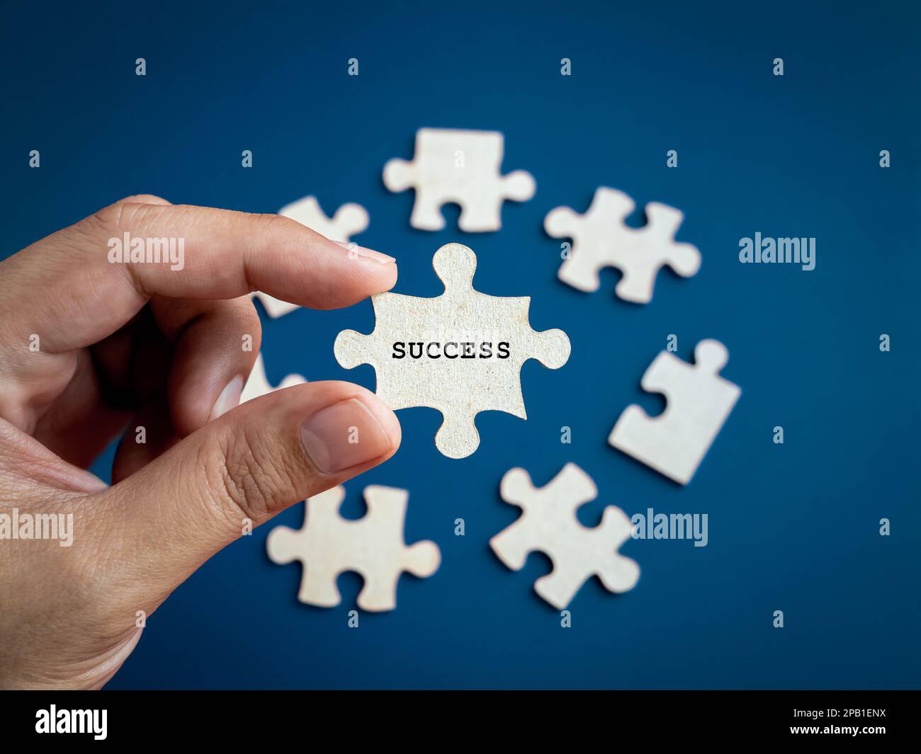 Success concept. Word "SUCCESS" showing on puzzle jigsaw piece holding ...