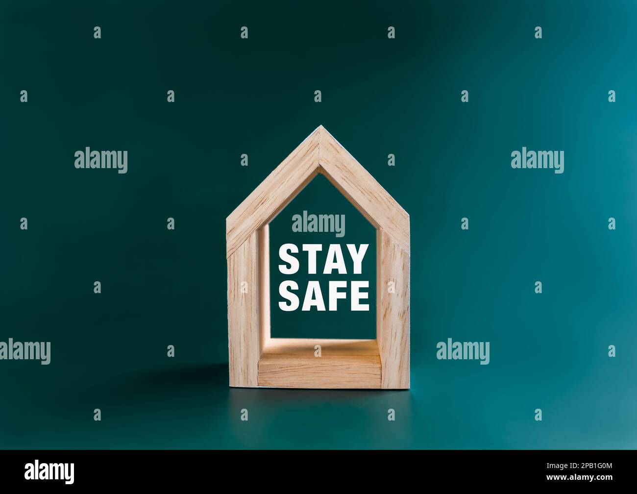 Stay safe concept. Word "Stay Safe" in wooden house isolated on aqua ...