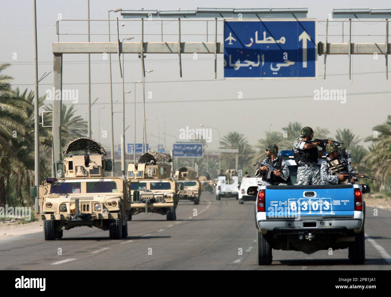 Iraqi national police, right, on a blue truck and in white vehicles ...