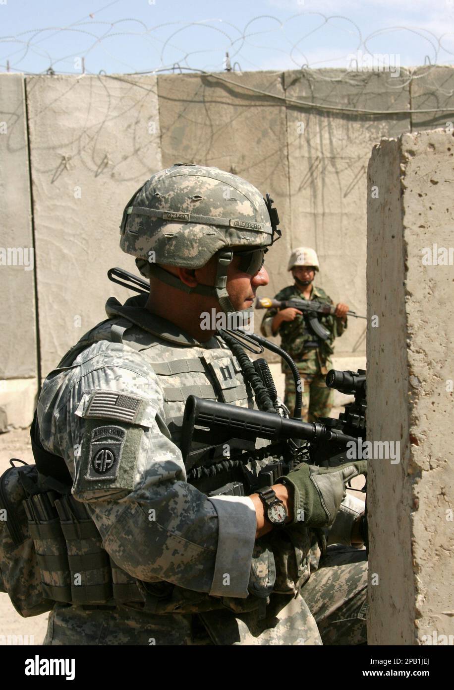 A U.S. soldier stands guard with an Iraqi national policeman, in ...