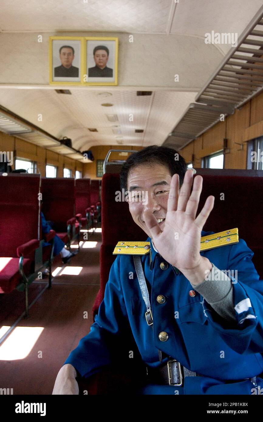 A North Korean police officer waves off a photographer on a train which ...