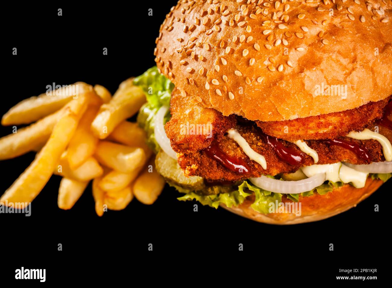 Double fried chicken burger with french fries onions cucumber and ...