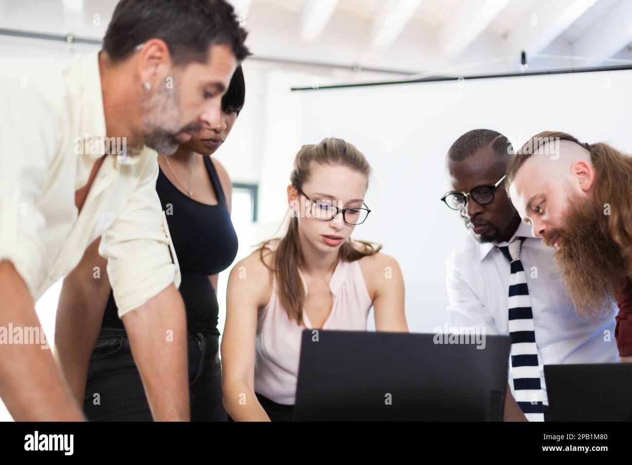 Multiracial business people working together at boardroom table at office. Successful team of ...