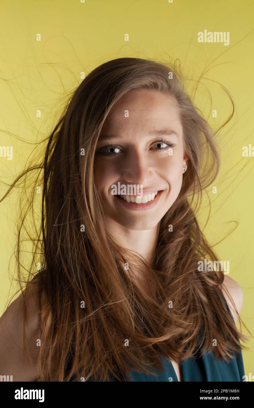 Beautiful girl with flowing hair against yellow background. Brunette ...