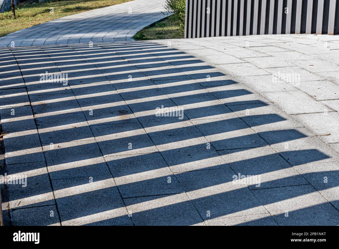 Floor of a pedestrian bridge with shadows of railing reflected on ...