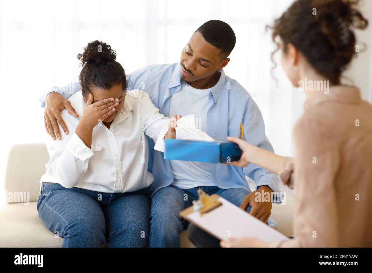 Black man comforting crying wife, couple attend family therapy Stock ...