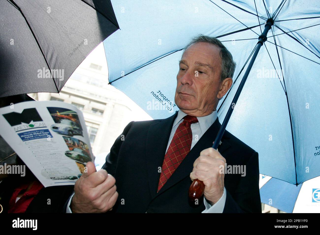 Mayor of New York, Michael Bloomberg looks at a brochure as he is being ...