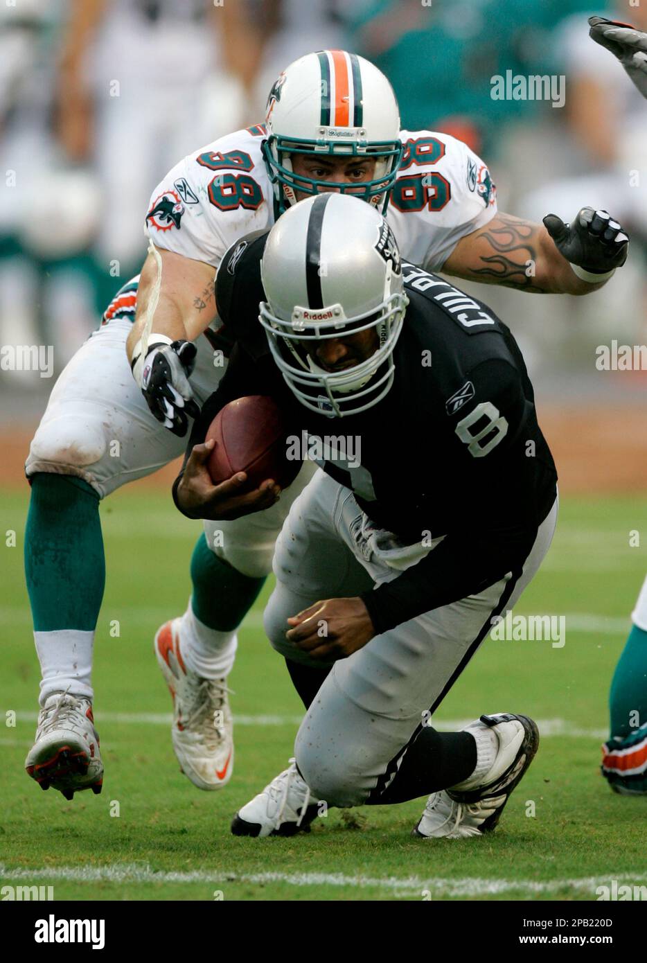 Miami Dolphins Matt Roth (98) stops Oakland Raiders quarterback Daunte ...