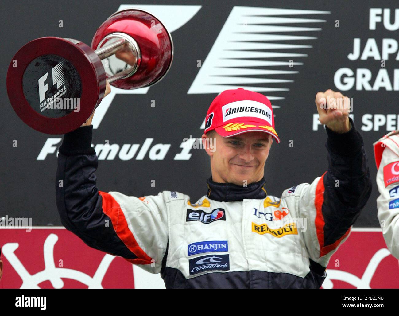 Finnish Renault driver Heikki Kovalainen holds up his trophy after ...