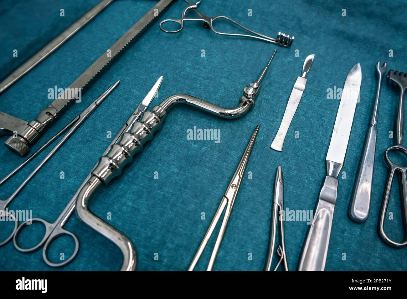 Set of steel surgical tools on blue cloth - real instruments used in ...