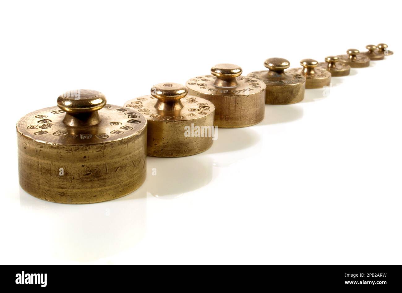 Old brass weights isolated on white background Stock Photo - Alamy