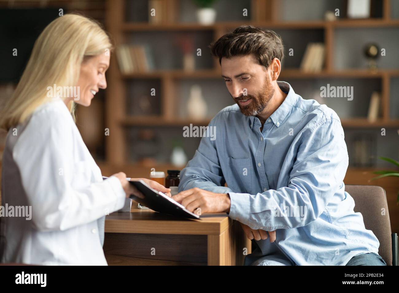 Male Patient Discussing Blood Test Results With Doctor During Checkup ...