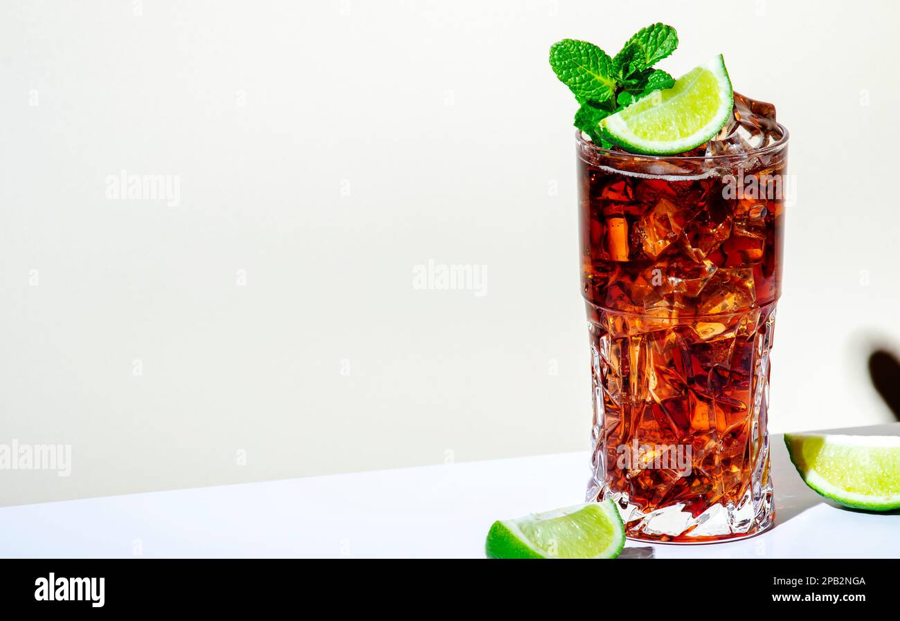 Rum cola cocktail with strong alcohol and ice, garnished with mint and ...