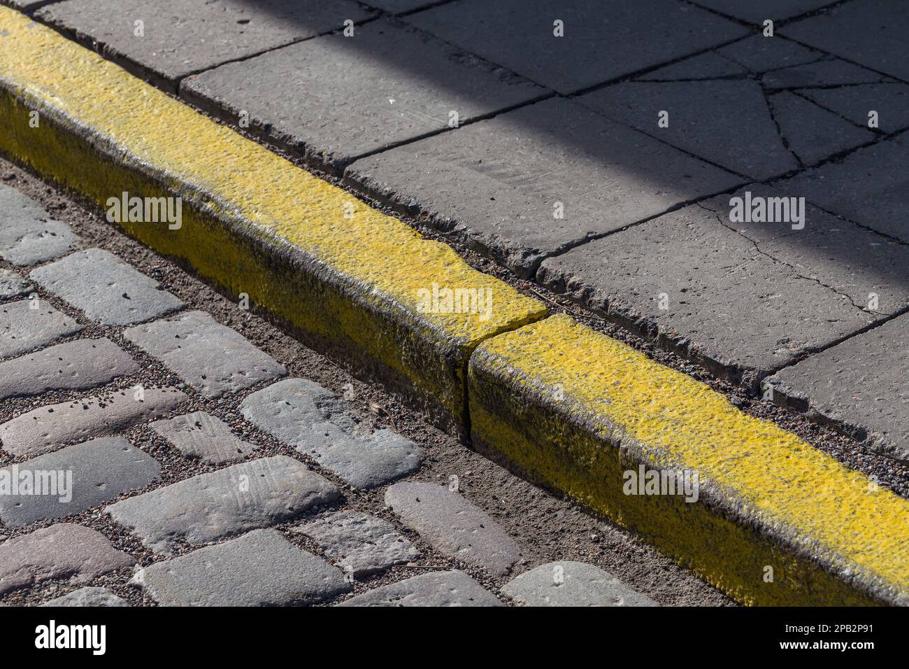 Yellow curb stone border in an old town road Stock Photo - Alamy