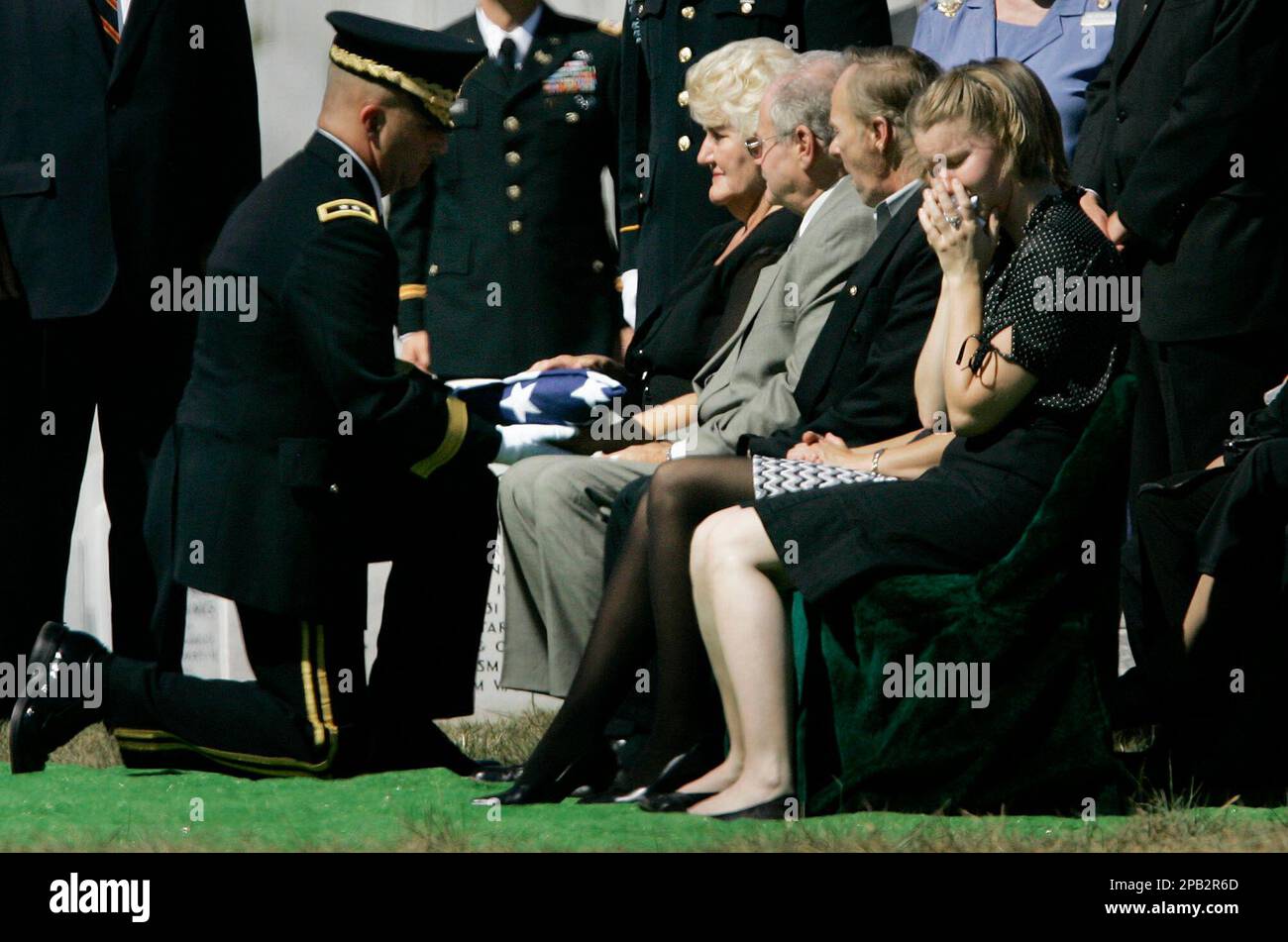 An Army two-star general presents a folded American flag to the family ...