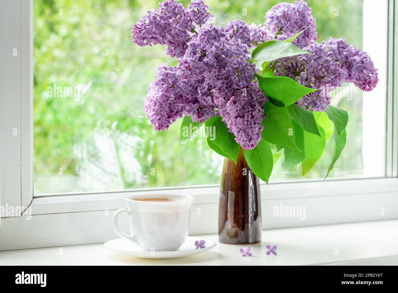 Home interior with a bouquet of blooming lilac flowers on the window ...