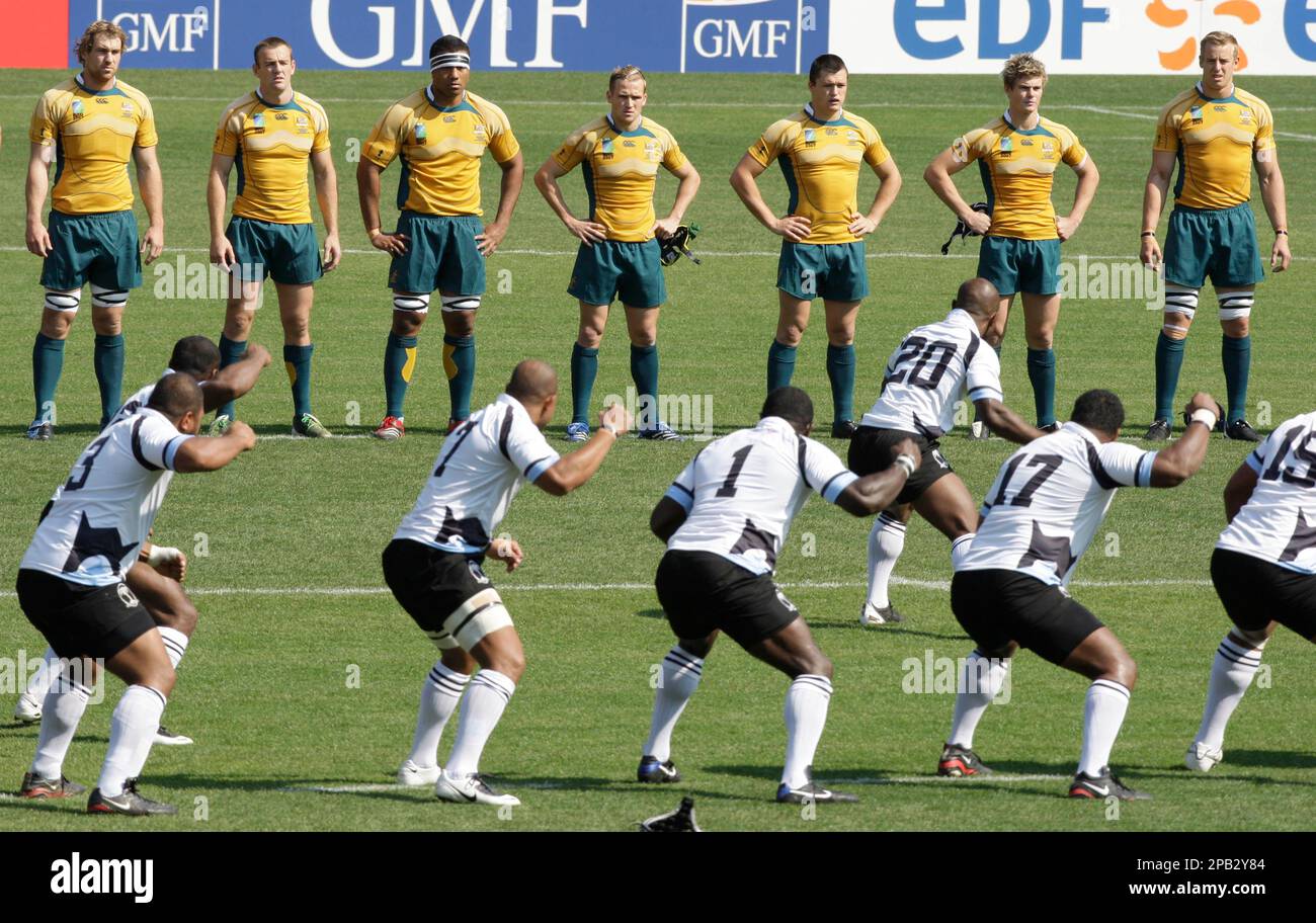 Australian players face the Fijian team, who perform their pre-match ...