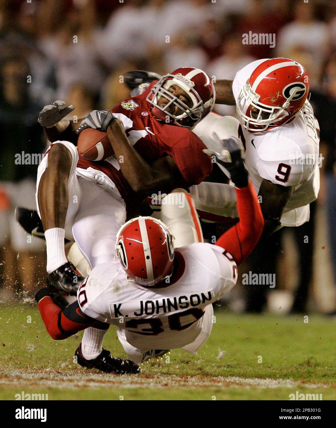 Alabama's Keith Brown, center, is tackled by Georgia defenders Kelin ...