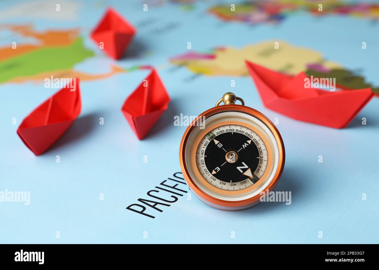 Bright paper boats and compass on world map Stock Photo - Alamy