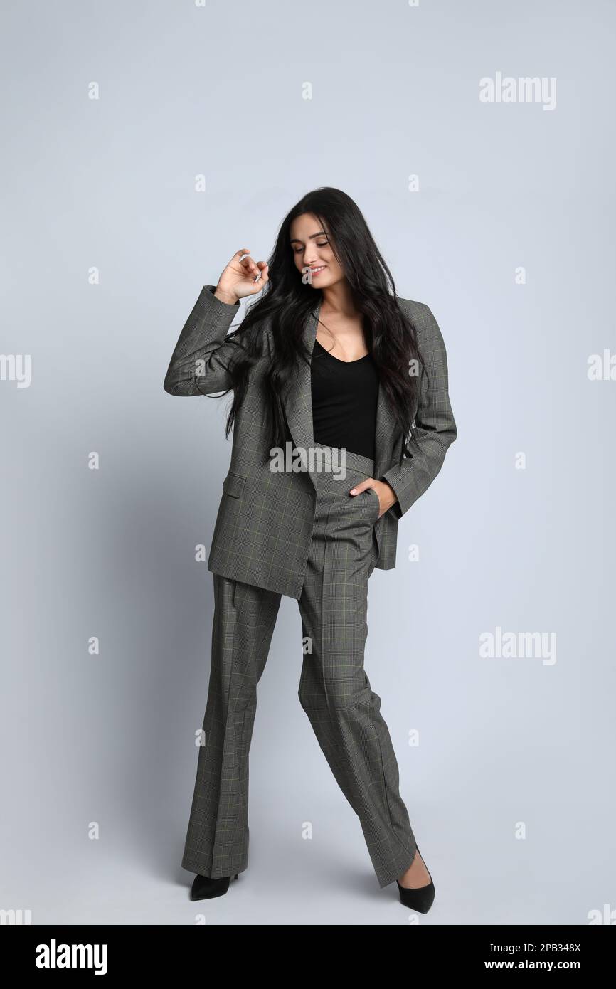 Full length portrait of beautiful woman in formal suit on light ...