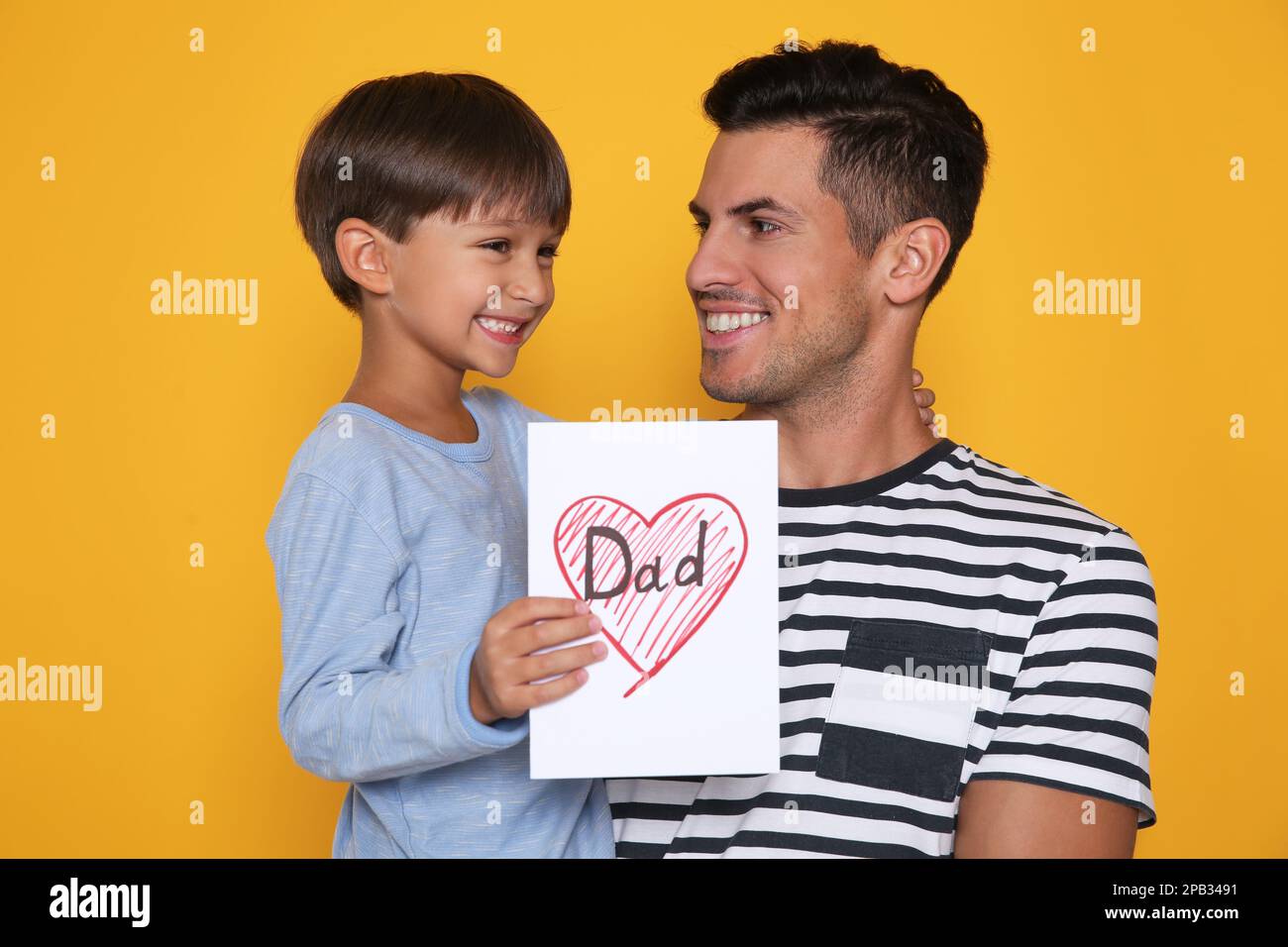 Little boy greeting his dad with Father's Day on yellow background ...