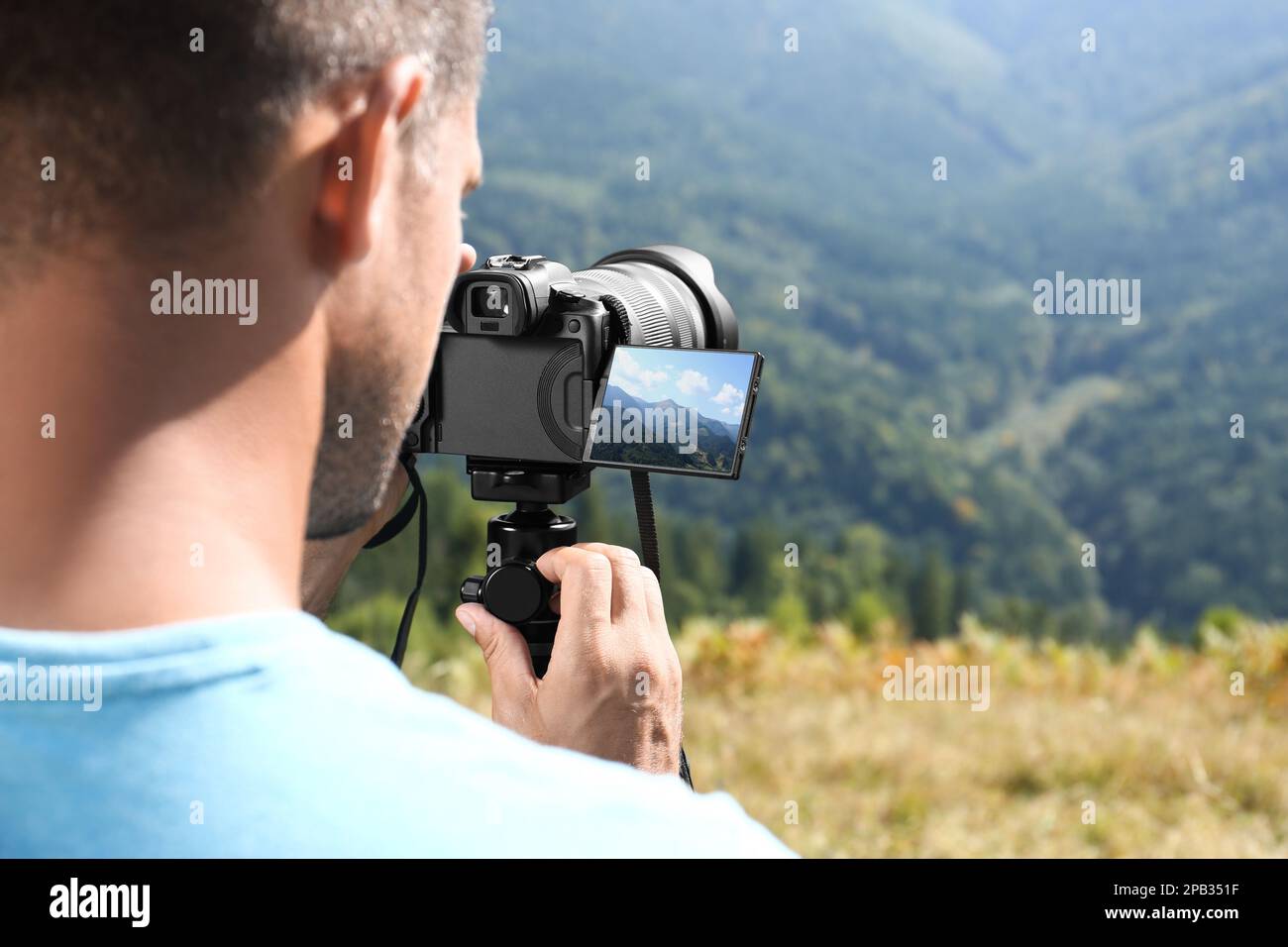 Man taking photo of nature with modern camera on stand outdoors Stock ...