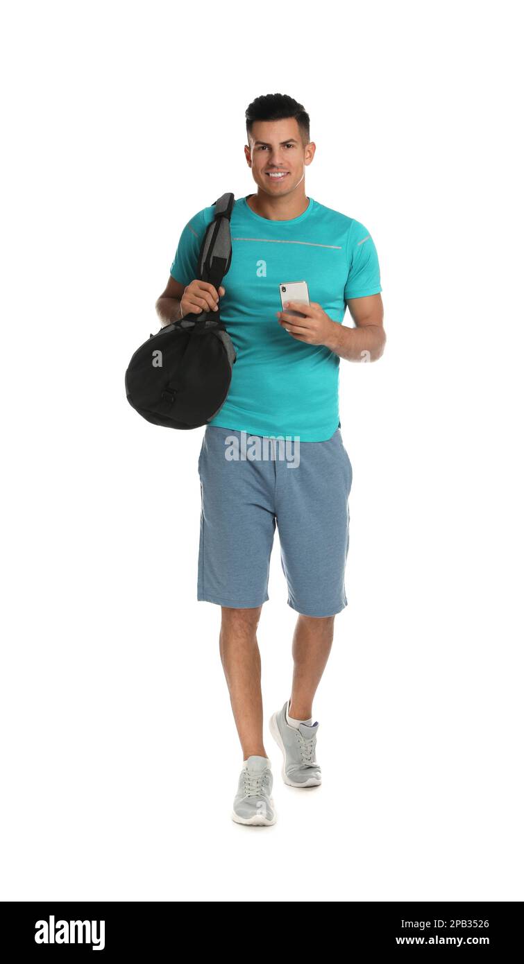 Handsome man with sports bag and smartphone on white background Stock ...