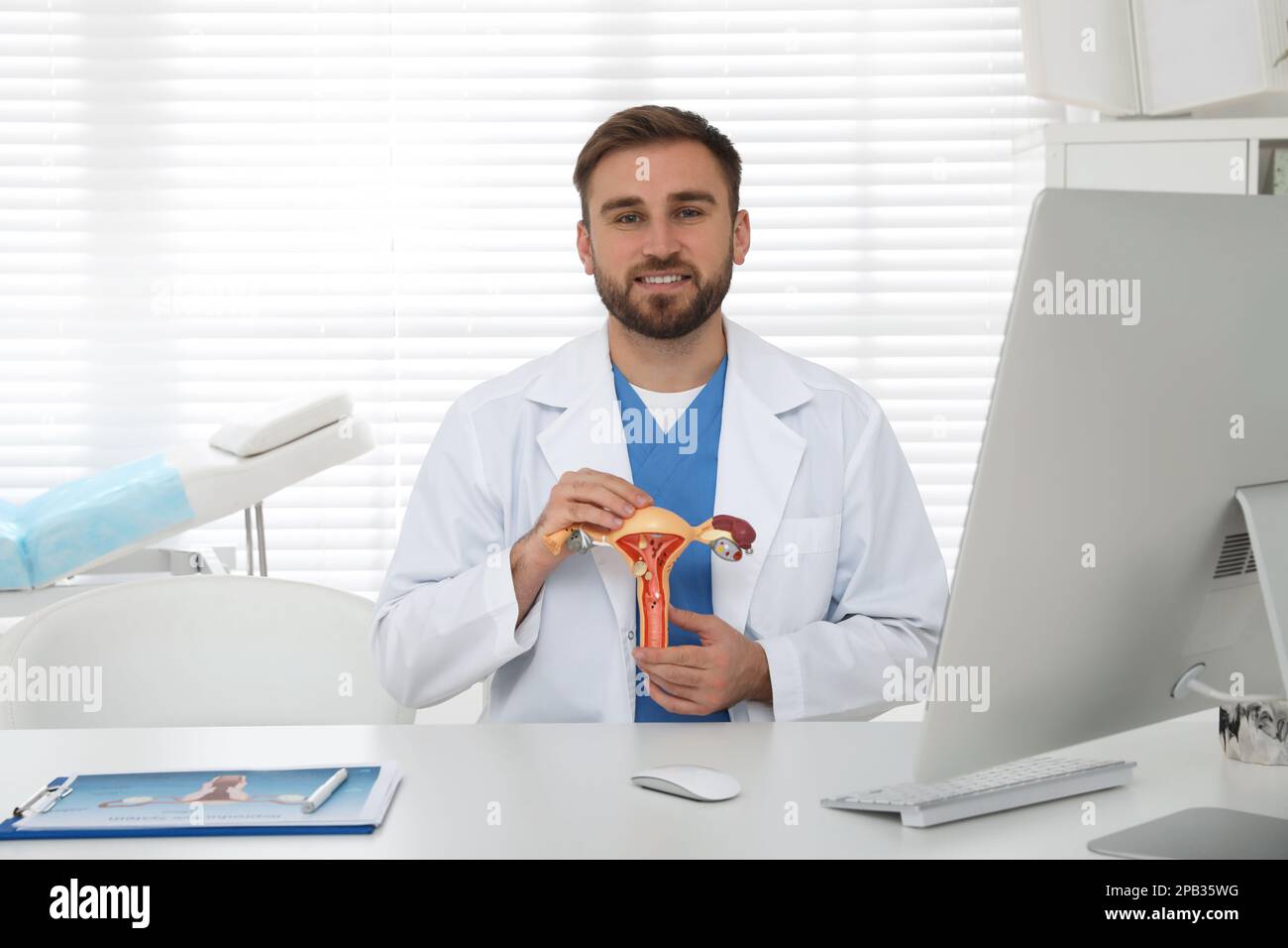 Gynecologist demonstrating model of female reproductive system in ...